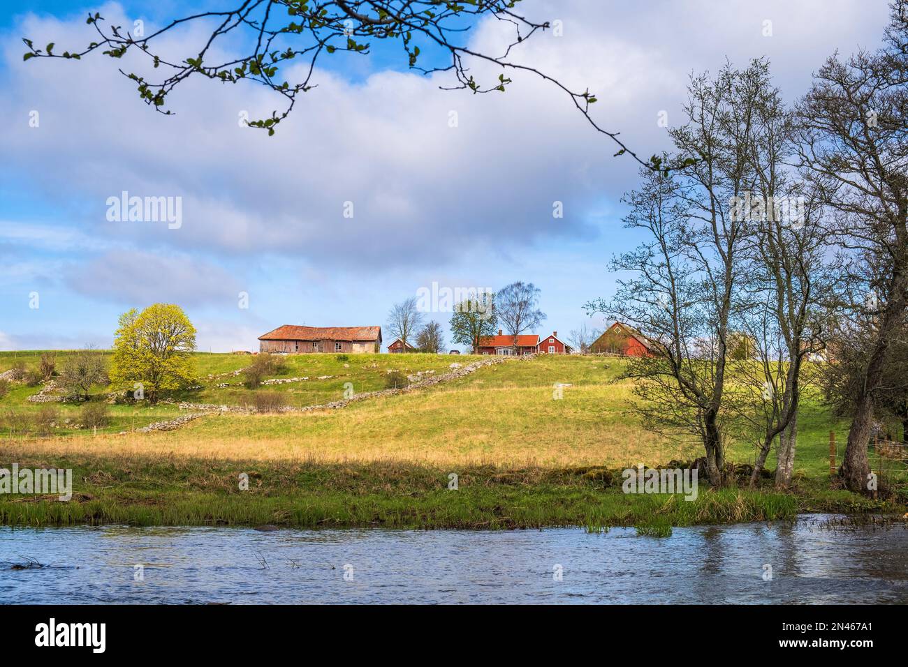 Farm on a hill in a rural landscape at a river Stock Photo - Alamy