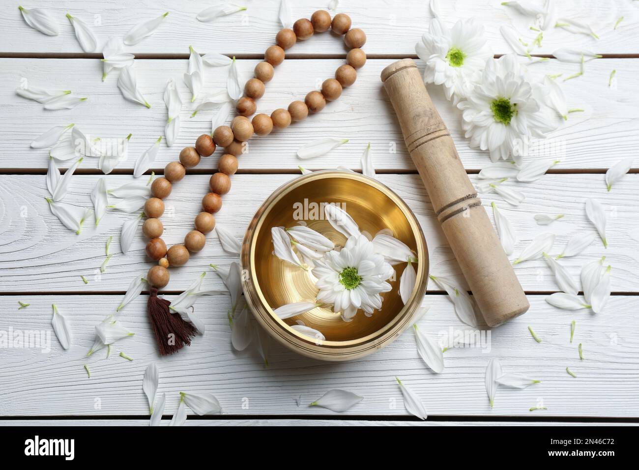 Flat lay composition with golden singing bowl on white wooden table ...