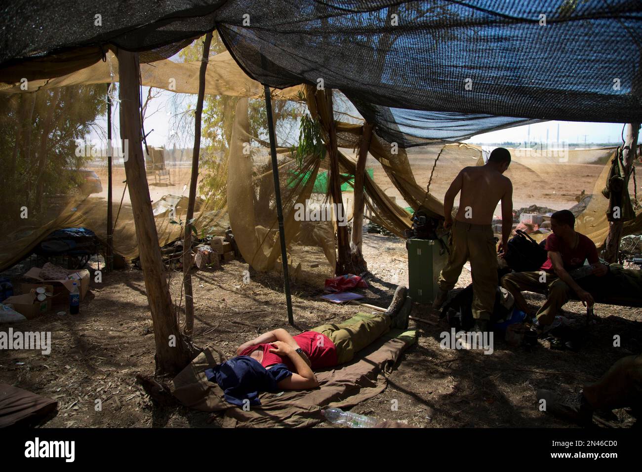 Israeli soldiers rest in an army staging area next to the Israeli Gaza ...