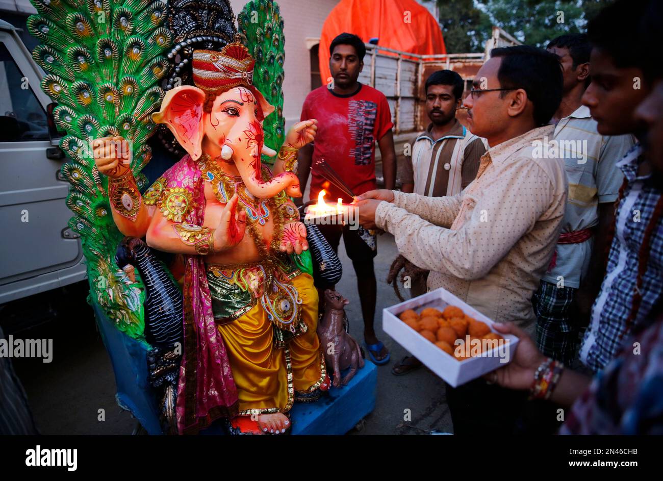 Hindu devotees perform rituals in front of an idol of elephant-headed ...