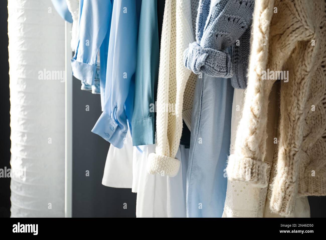 Stylish women's clothes hanging indoors. Interior design Stock Photo ...