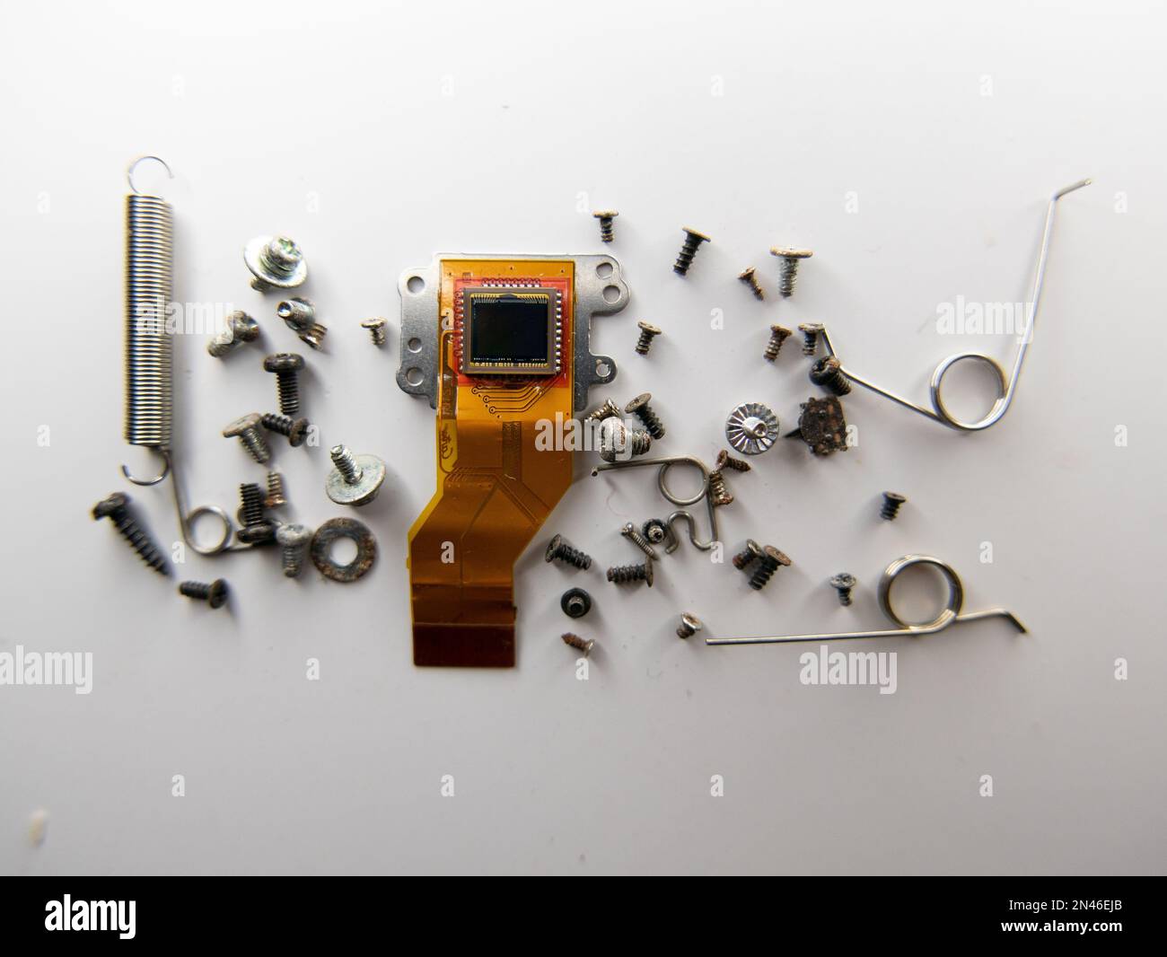 A top view of a digital camera sensor, screws, tension springs on a ...