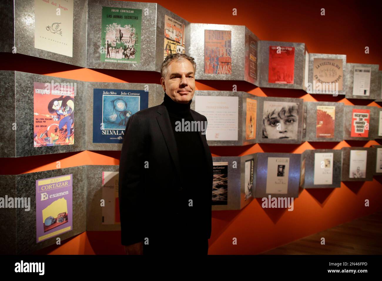 Christophe Karvelis poses near several book covers by the late writer ...