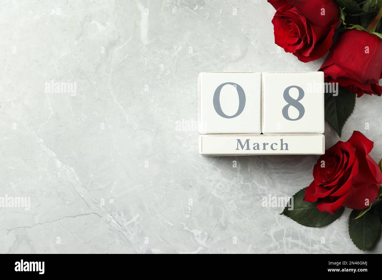 Block calendar with date 8th of March and roses on light grey marble ...