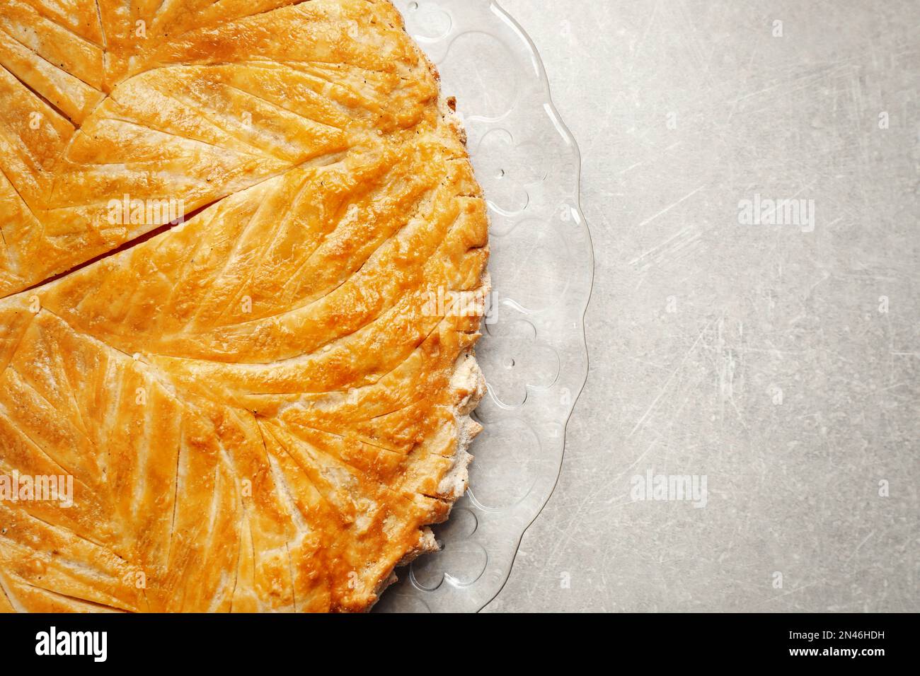 Traditional galette des rois on light grey table, top view. Space for ...