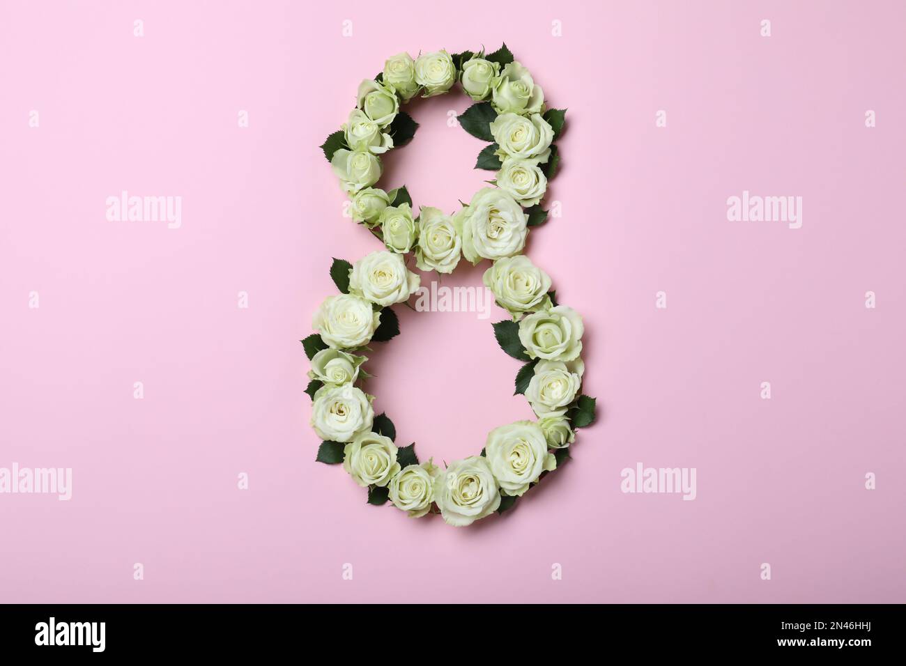 Number 8 made with white roses on pink background, flat lay ...