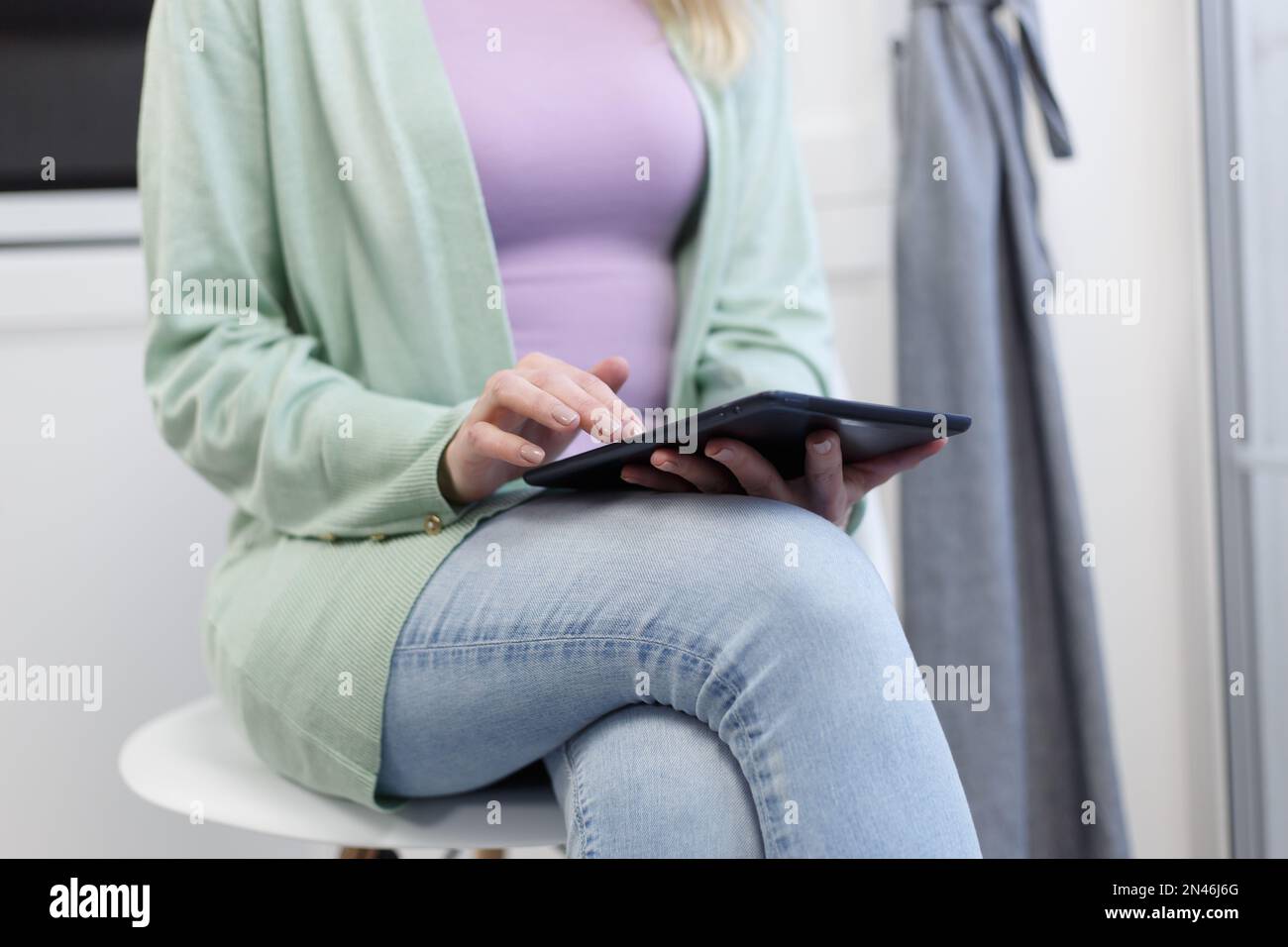 Adult woman browsing internet on tablet computer at home ...