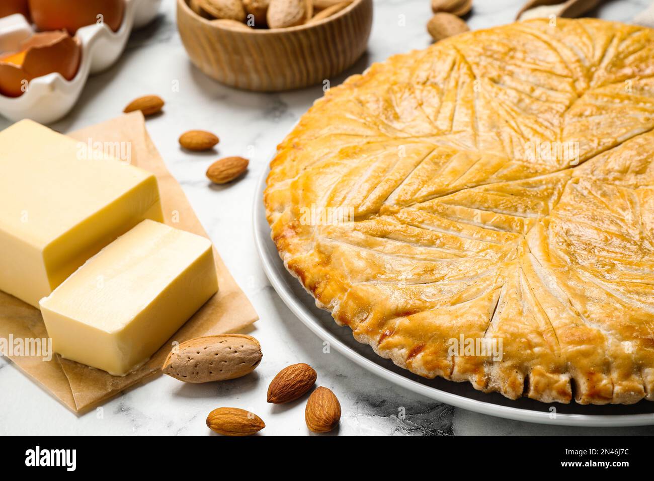 Traditional galette des rois and ingredients on white marble table ...