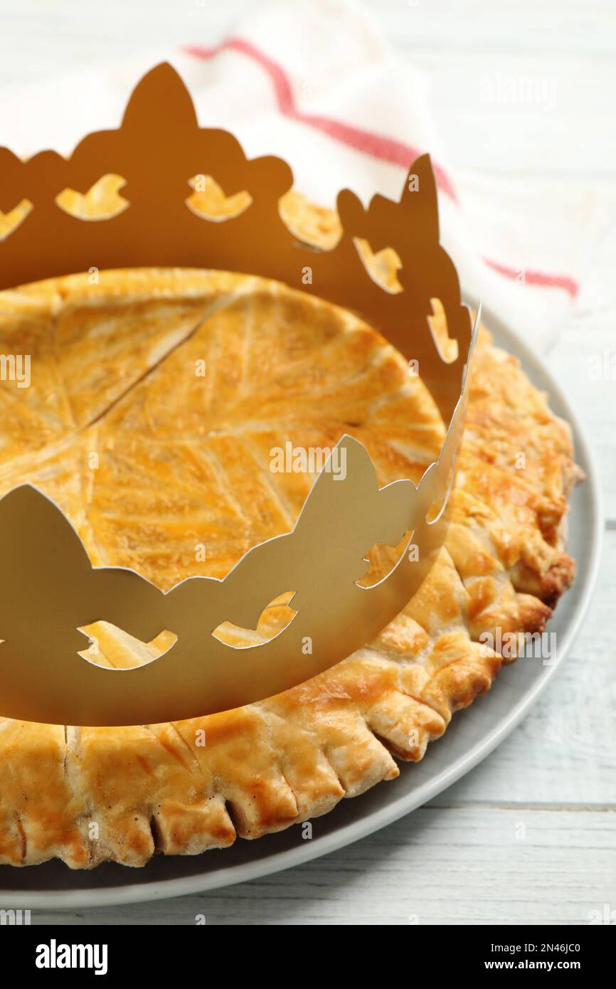 Traditional galette des Rois with paper crown on white wooden table ...