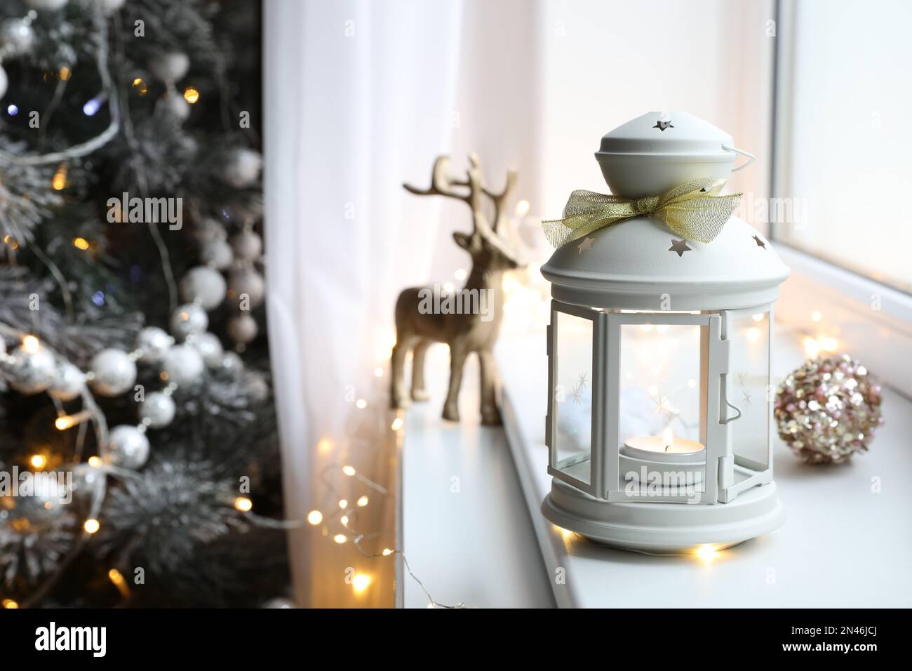 Beautiful Christmas lantern and other decorations on window sill in ...