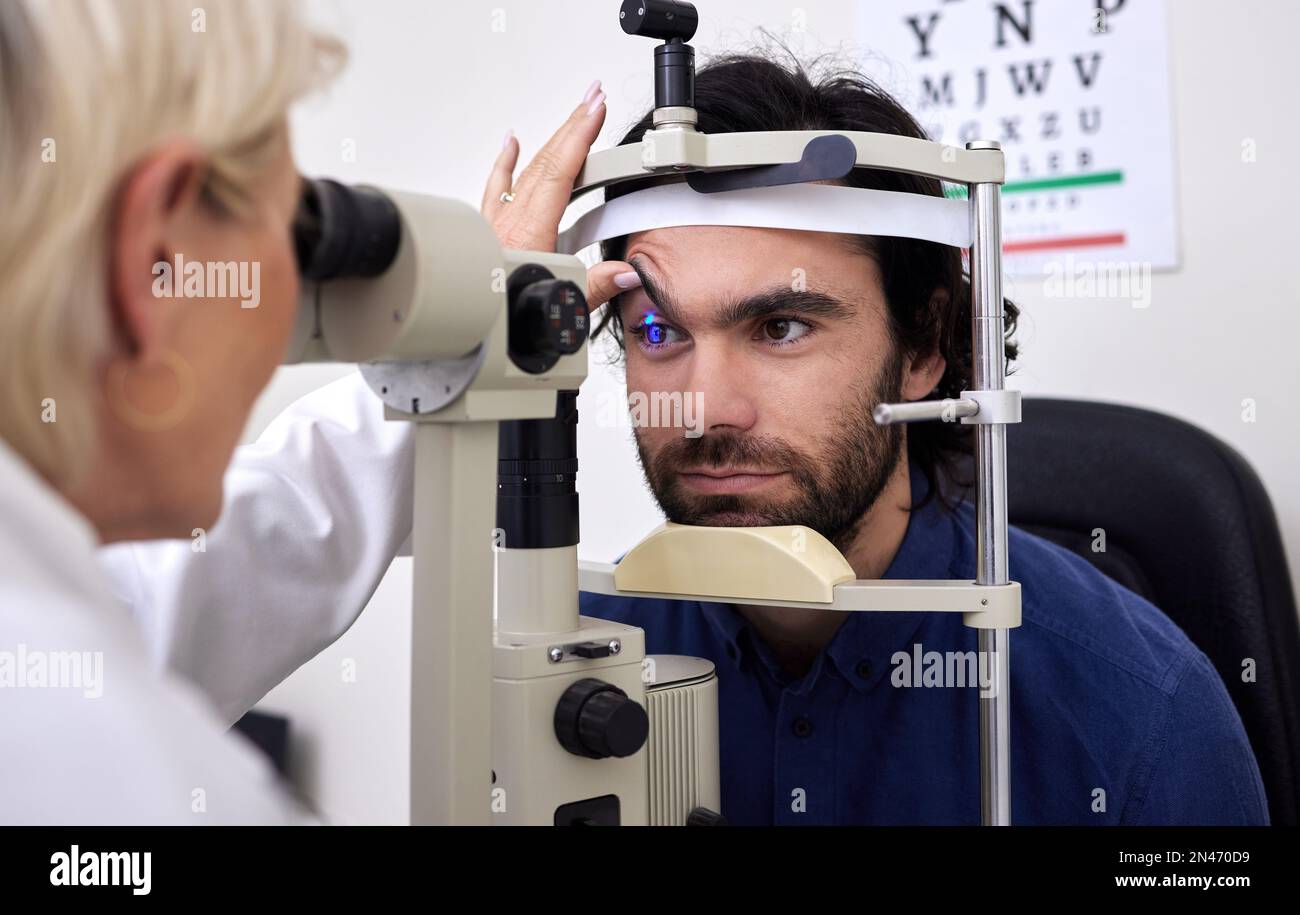 Patient man, eye exam or test for vision with laser lens and doctor at ...