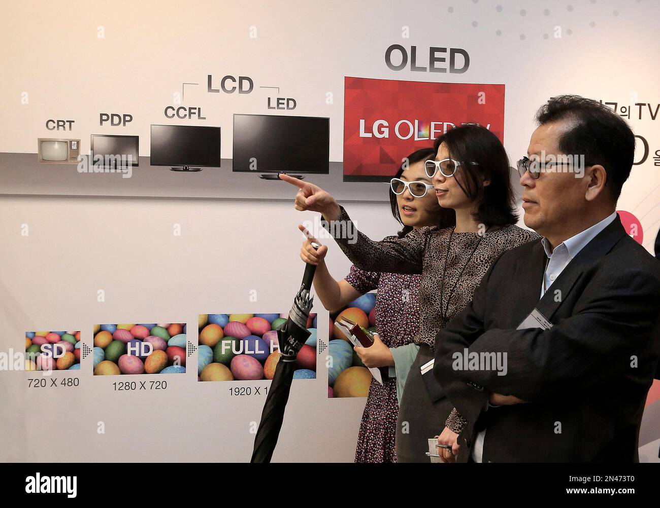 Visitors wearing 3-D glasses look at LG Electronics' Ultra Organic ...