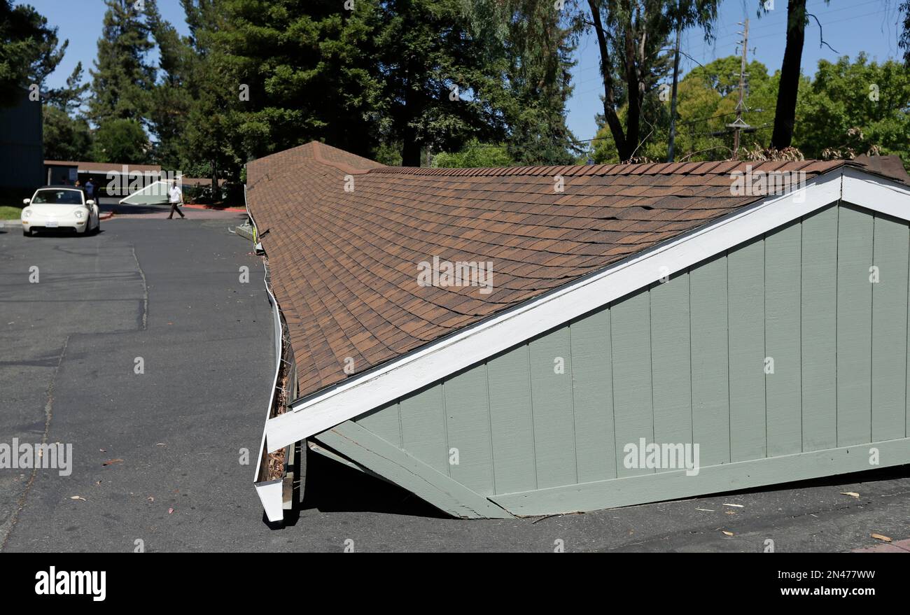 A carport is seen collapsed onto vehicles Sunday, Aug. 24, 2014, in ...