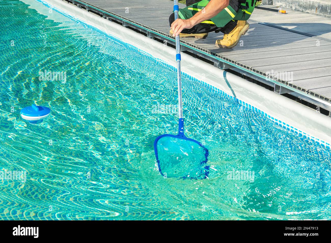 Cleaning Backyard Garden Swimming Pool with Skimmer Net Stock Photo - Alamy