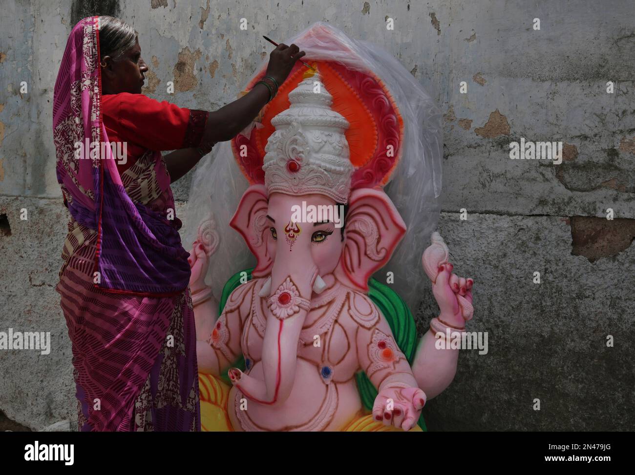 An Indian artist paints an idol of elephant-headed Hindu god Ganesha ...