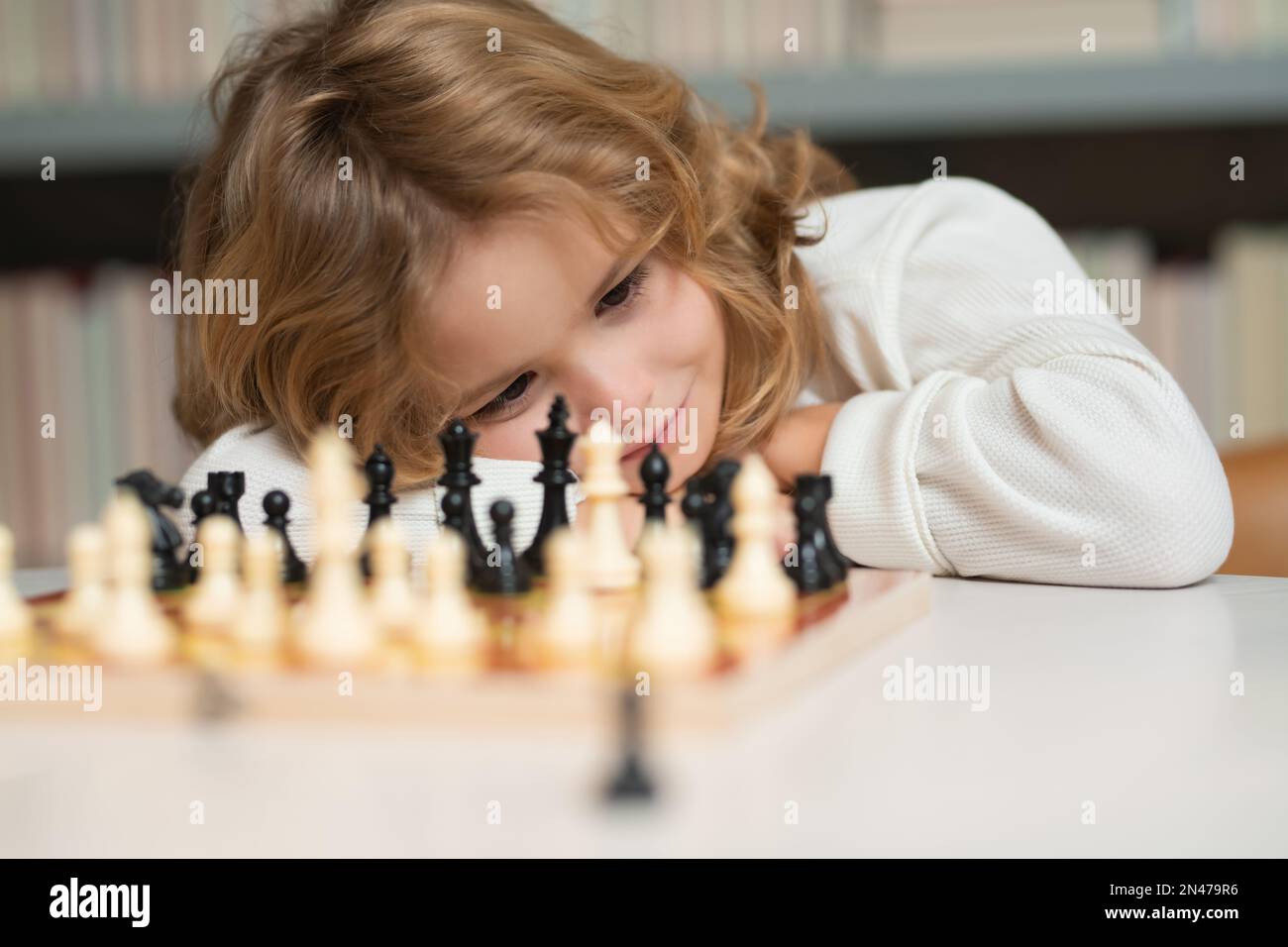 Smart kid playing chess. Clever child thinking about chess. Kids early ...