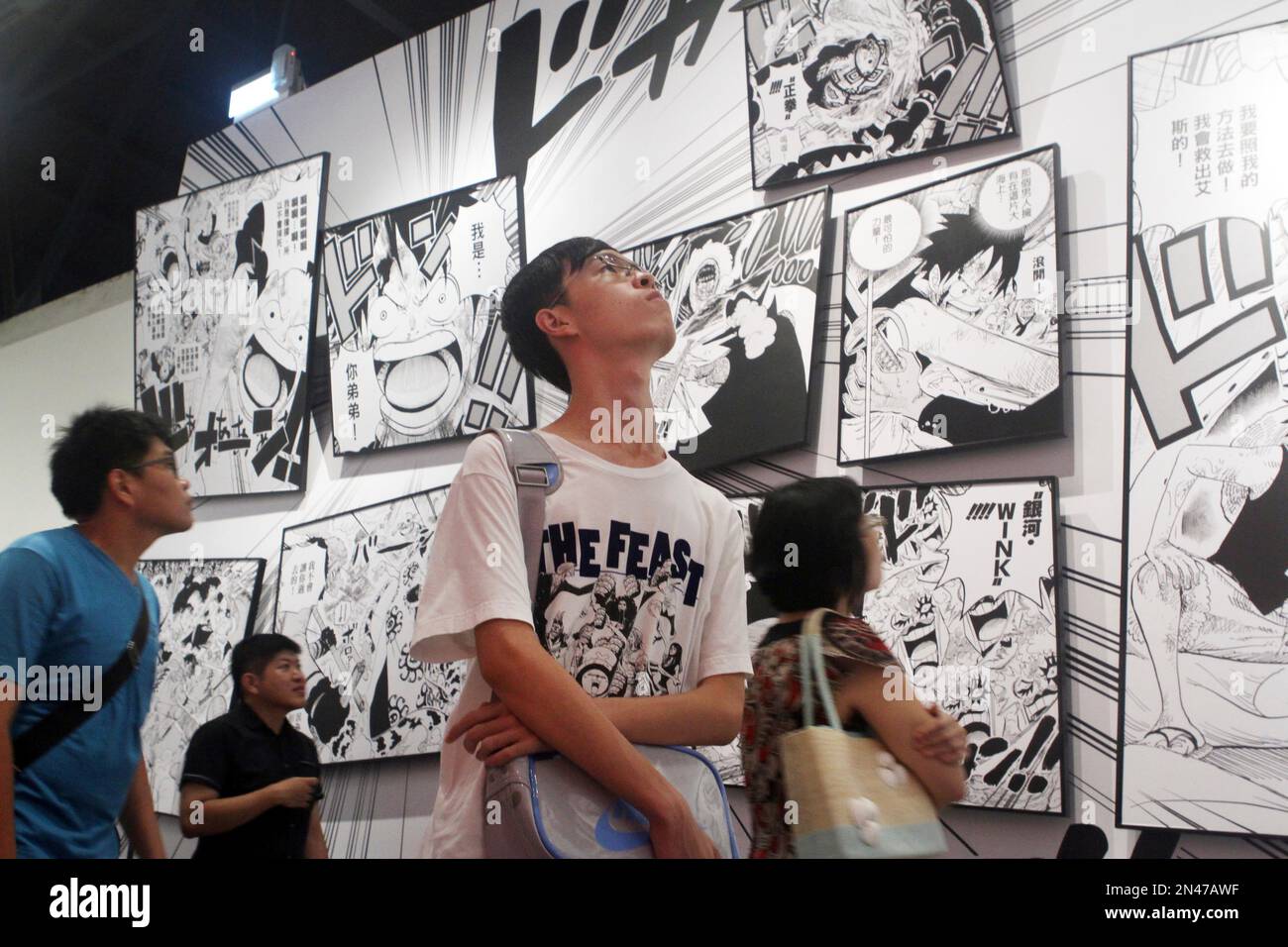 Visitors stop and watch comic characters in frames with balloon ...