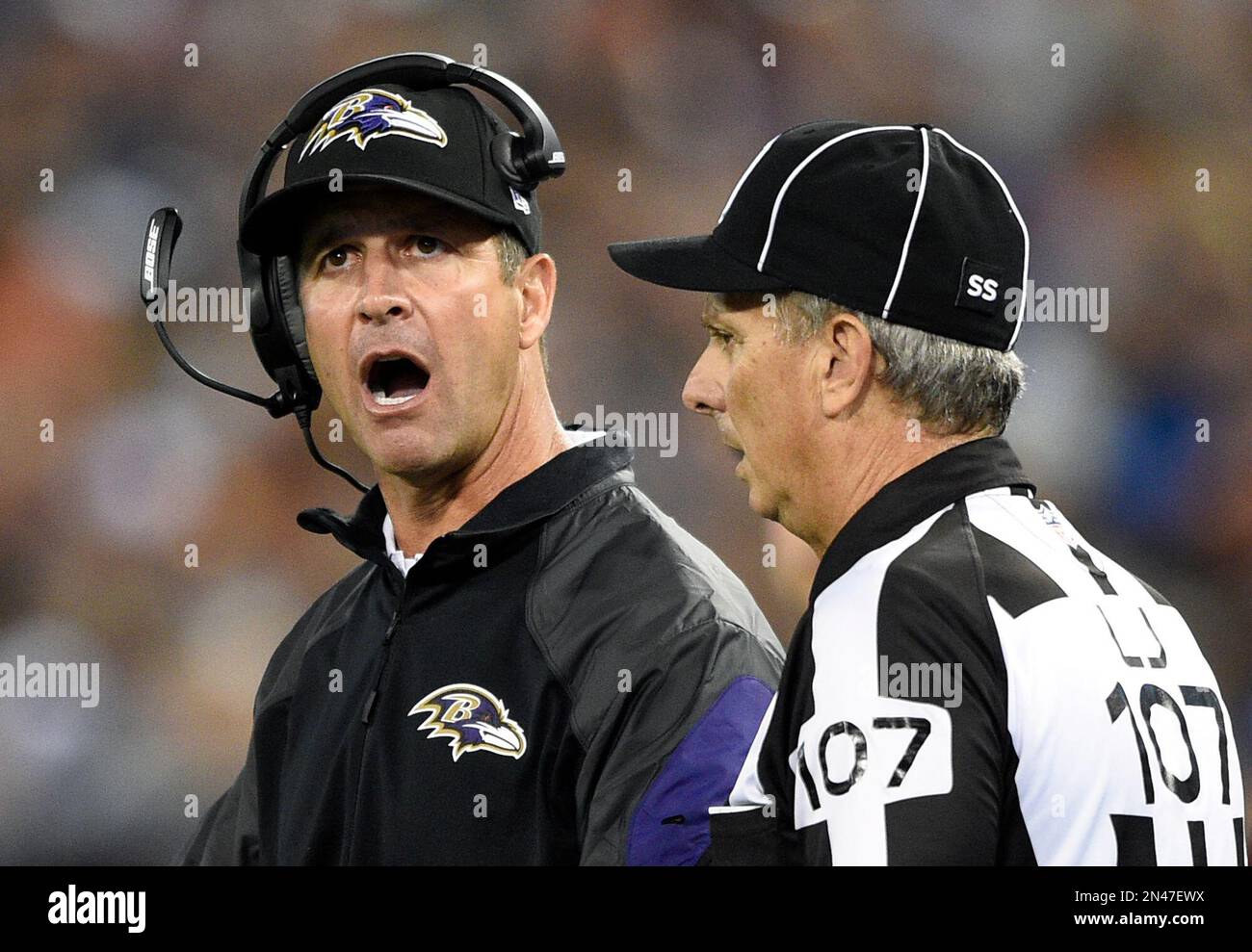 Baltimore Ravens head coach John Harbaugh, left, speaks with line judge ...