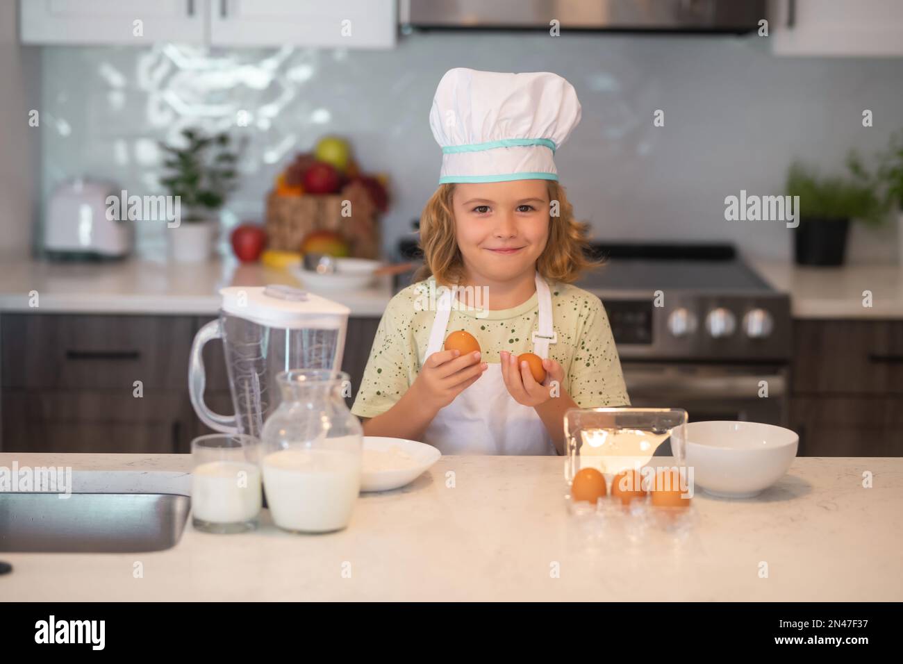 Child chef cook is learning how to make a cake in the home kitchen ...