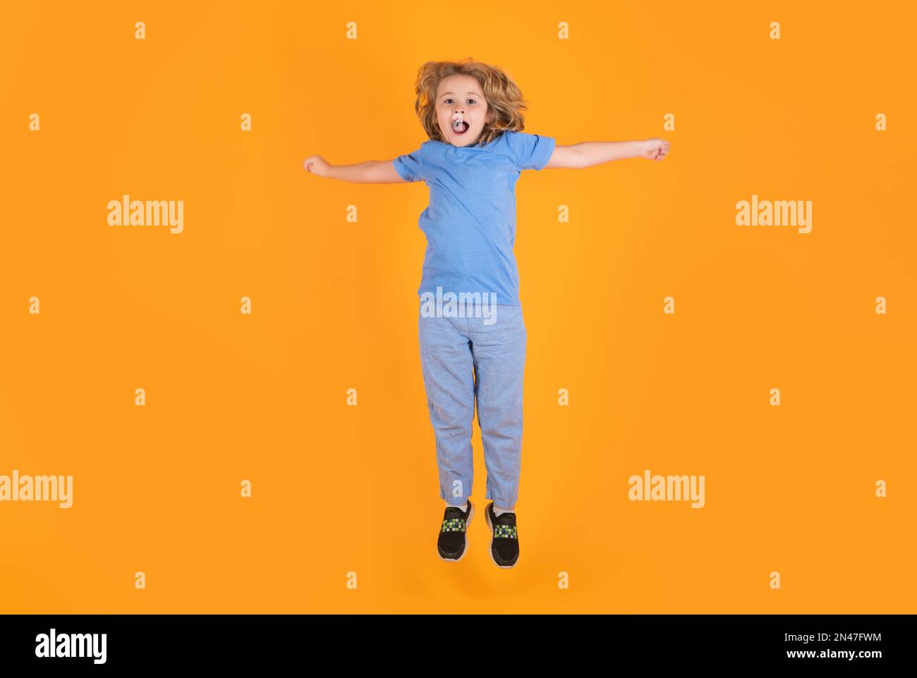 Full length of excited kid jumping. Energetic kid boy jumping and ...