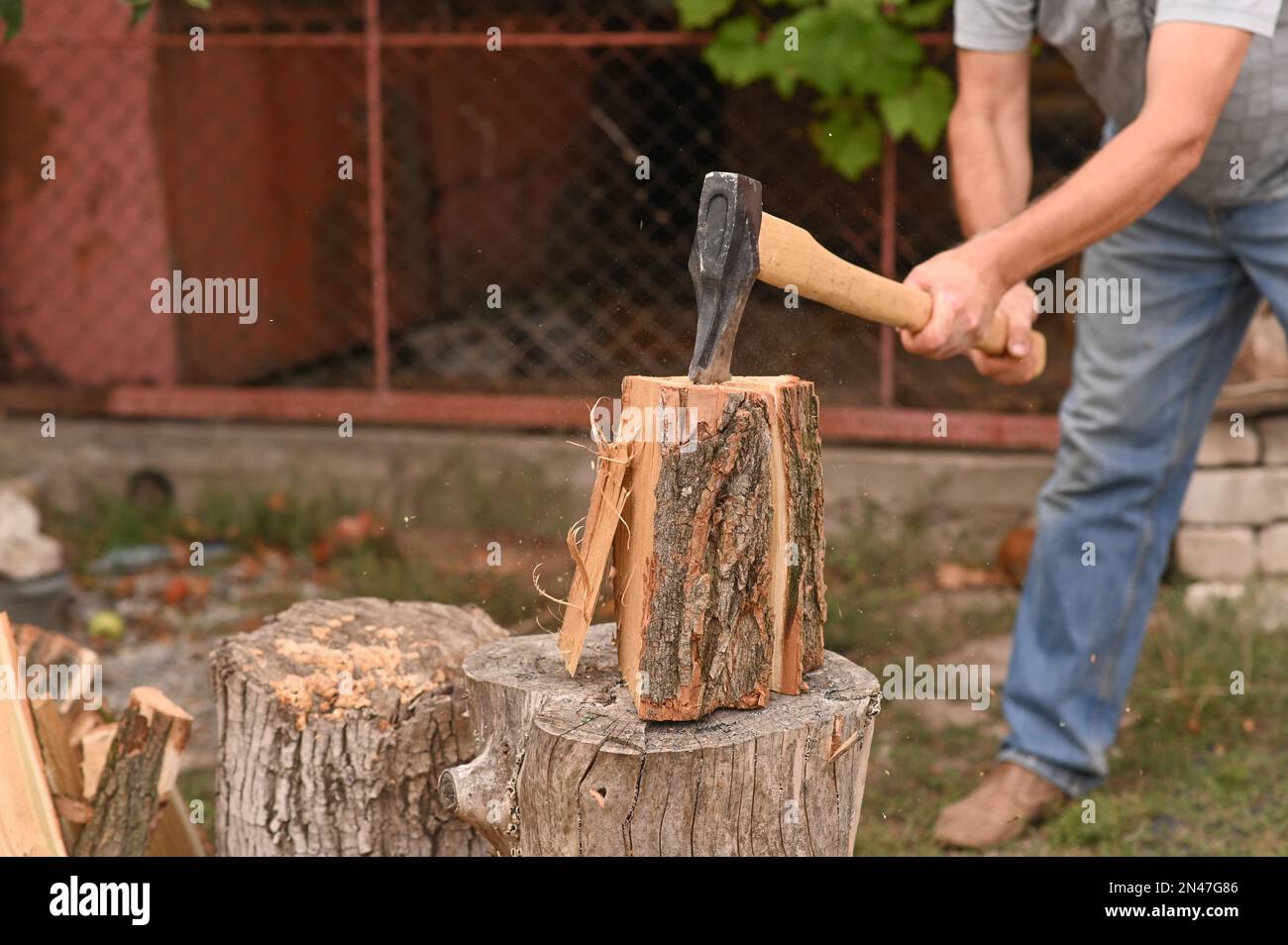 a man is chopping wood with an axe Stock Photo - Alamy