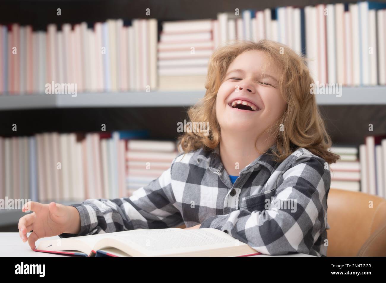 Kid reading a book in a school library. School boy education concept ...
