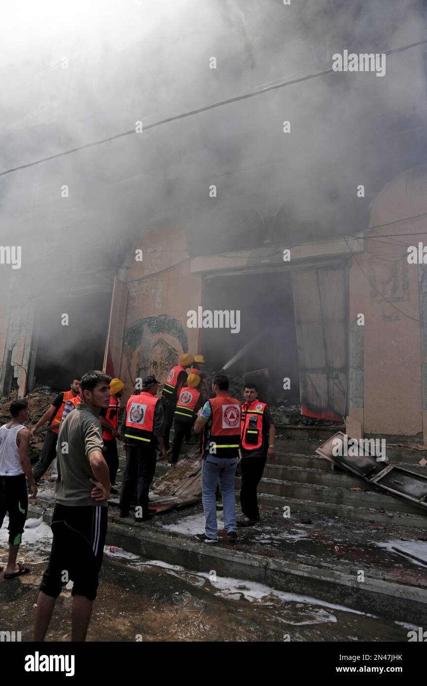 Palestinian firefighters extinguish a fire in a carpentry shop ...