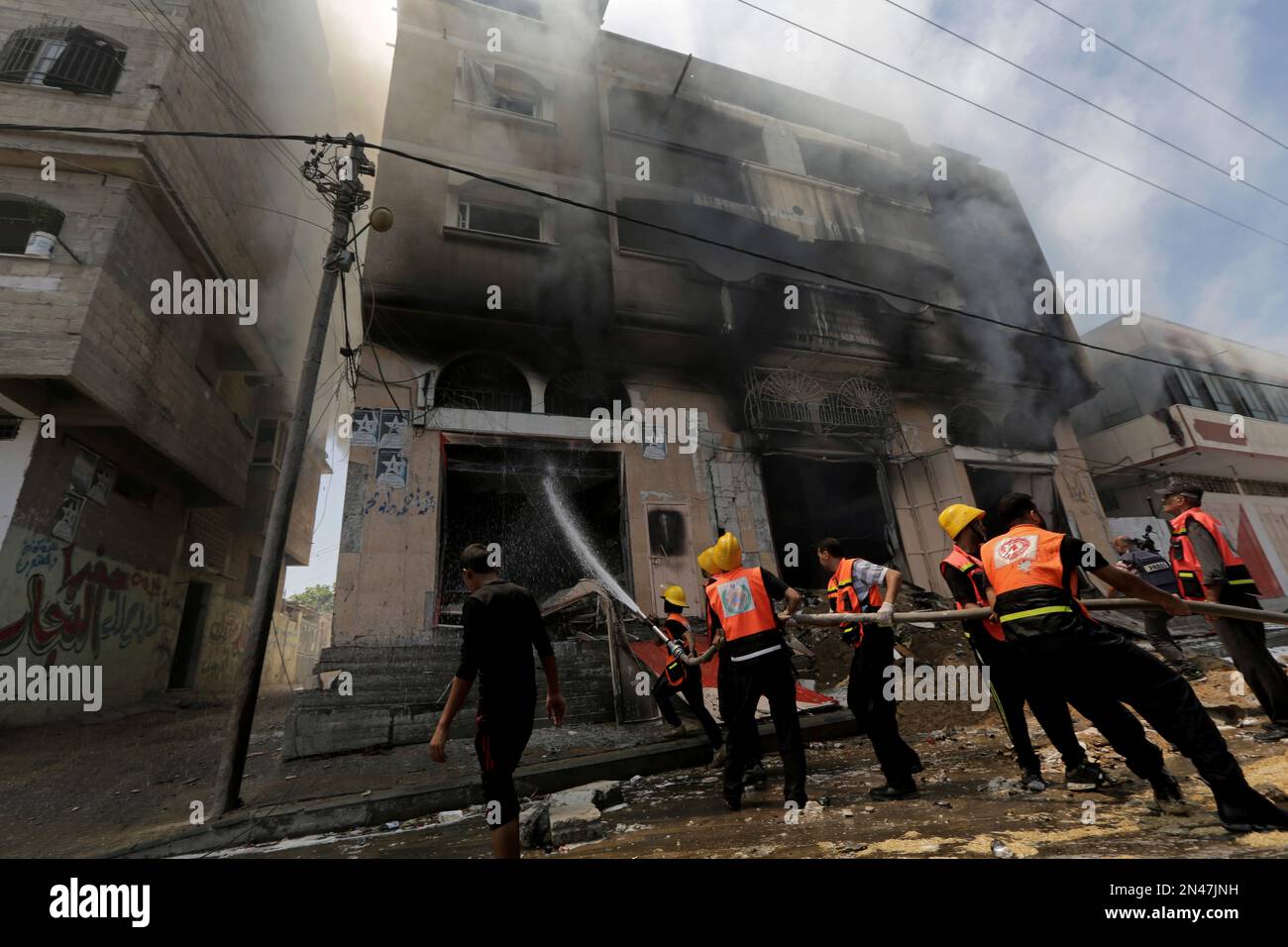 Palestinian firefighters extinguish a fire in a carpentry shop ...