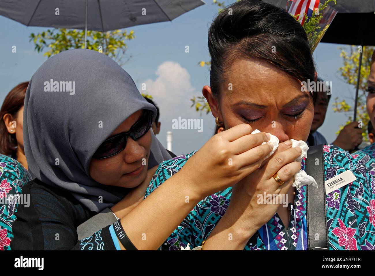 A Malaysia Airlines crew member cries as she waits outside Bunga Raya ...