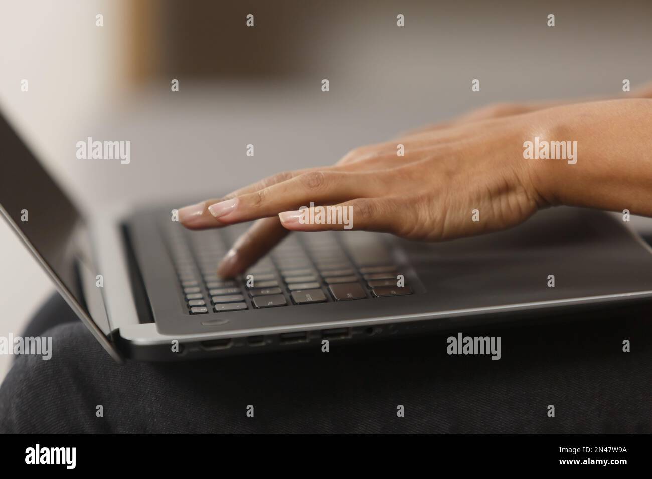 Black female hands typing text on laptop keyboard. Unrecognizable BIPOC woman working on modern ...