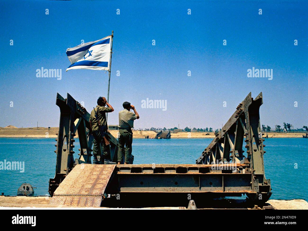 Israeli soldiers stand at the destroyed bridge at Geneffa looking over ...
