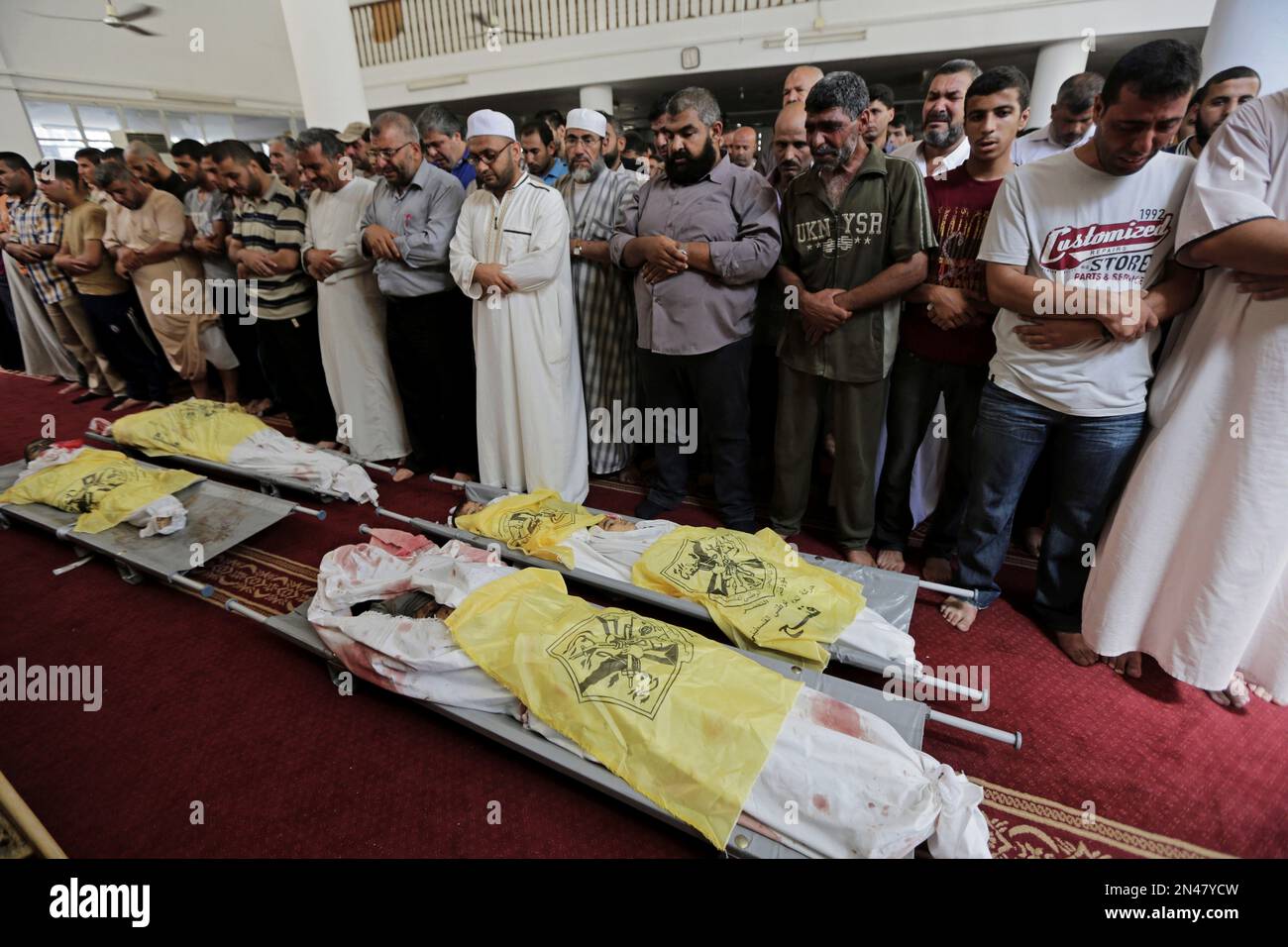 Palestinian relatives pray over bodies of father Nasr al-Rifi, 35, and ...