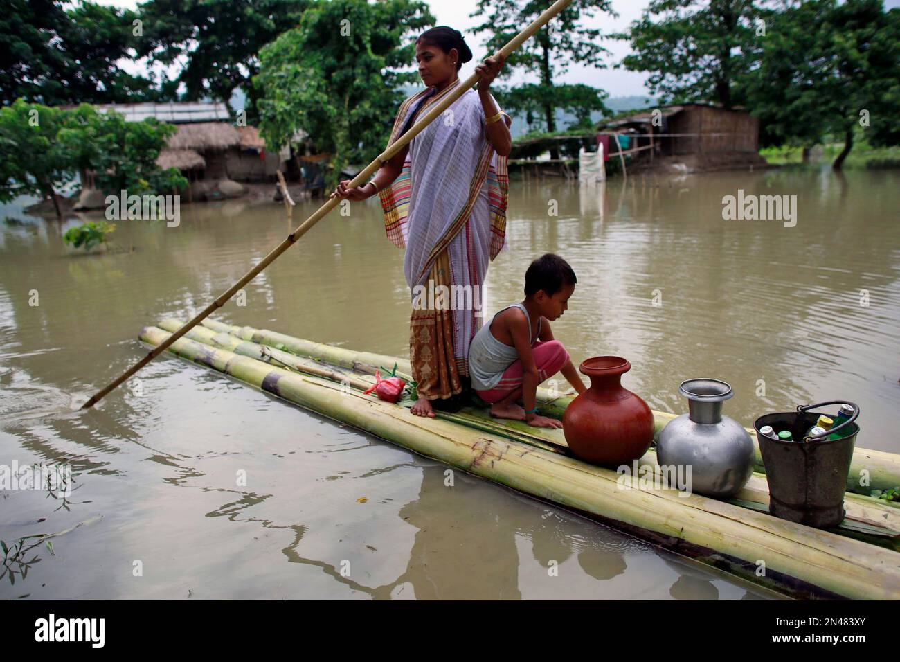 In this Tuesday, Aug. 19, 2014 photo, an Indian woman paddles a banana ...