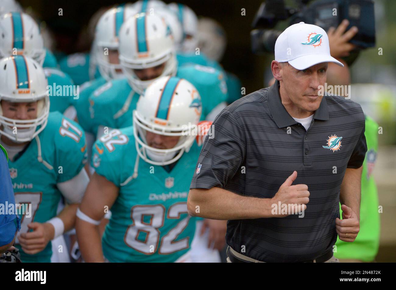 Miami Dolphins head coach Joe Philbin, right, leads the team onto the ...