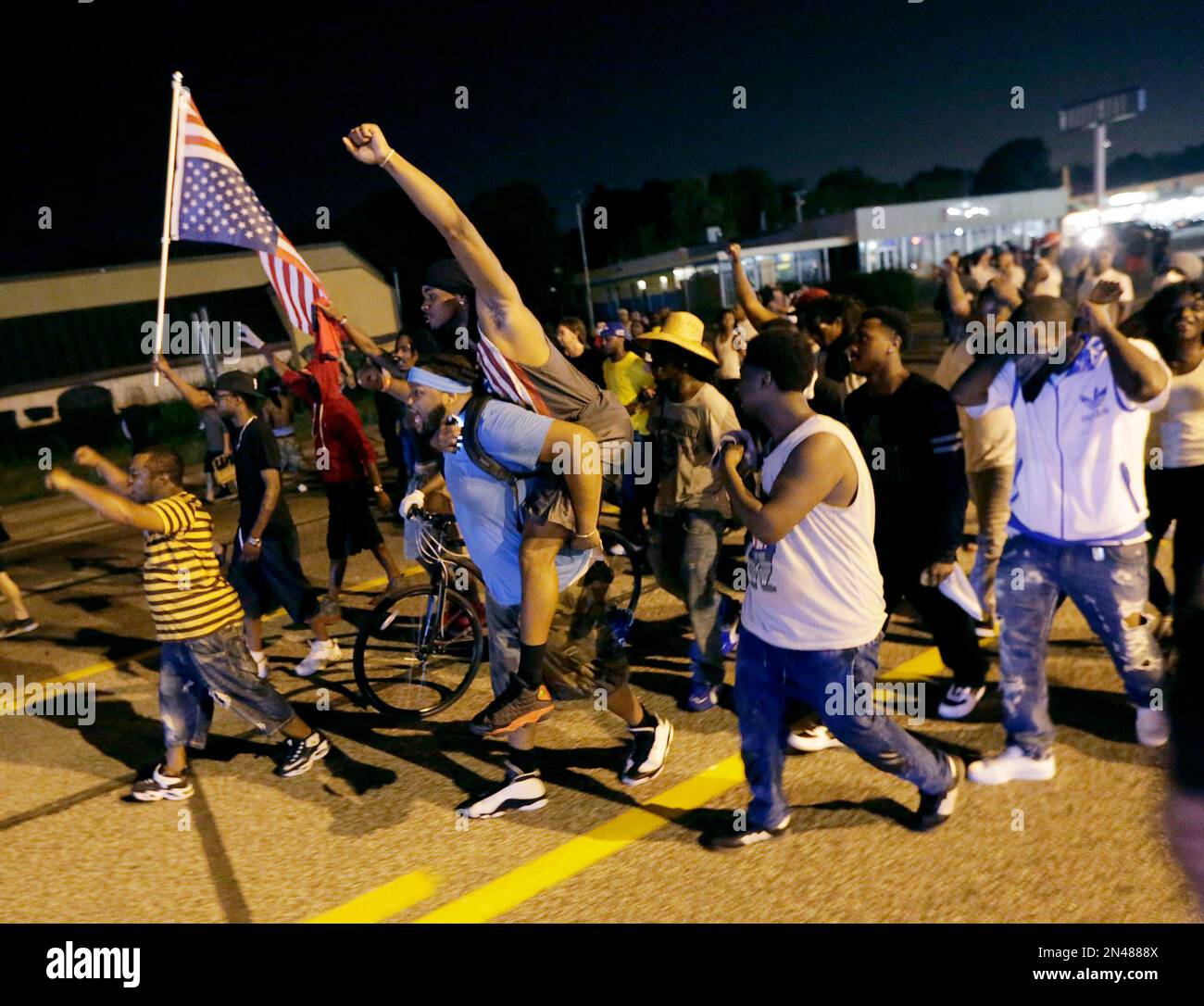 People march down the street after a standoff with police Monday, Aug ...
