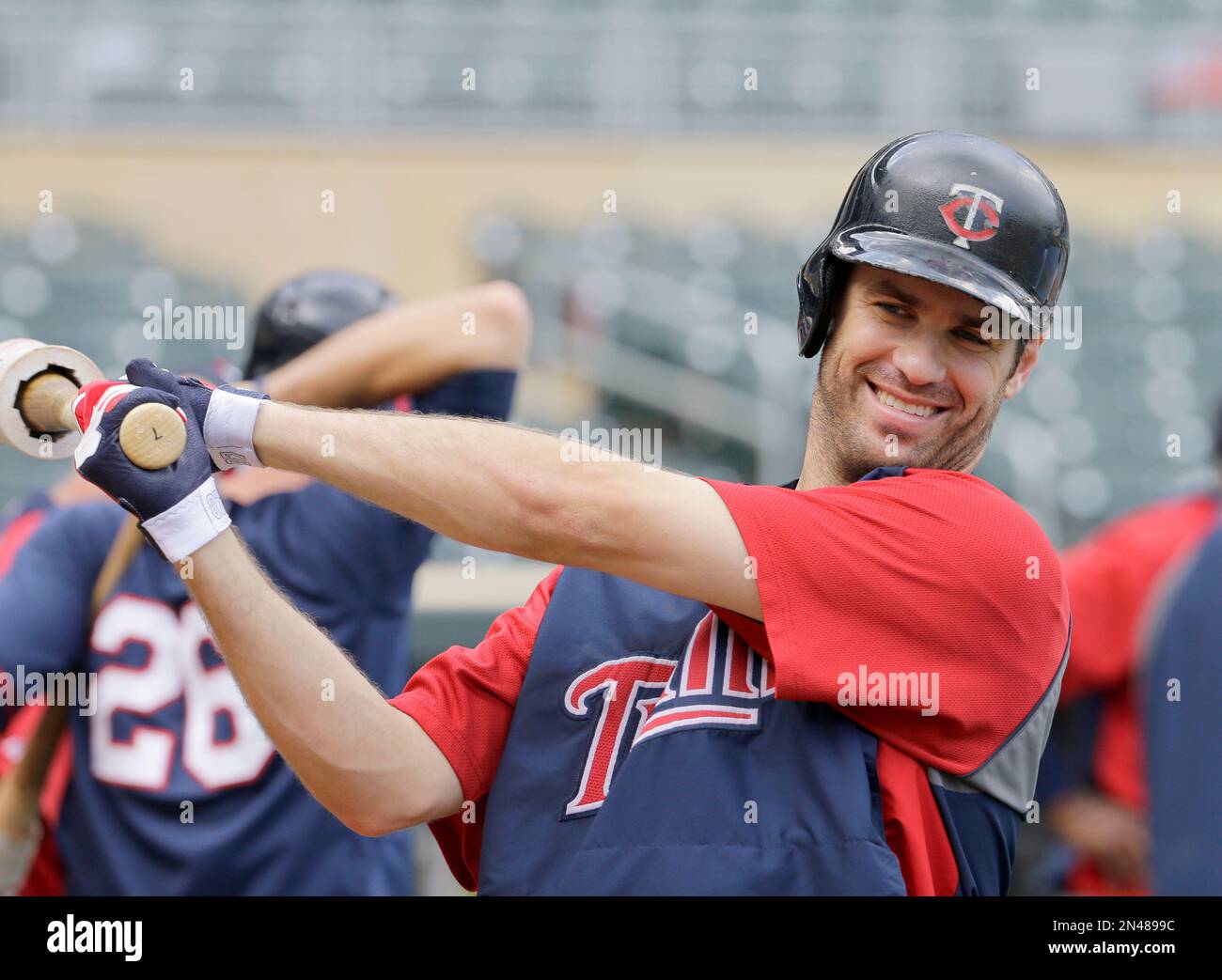 Minnesota Twins first baseman Joe Mauer smiles as he warms up before a ...