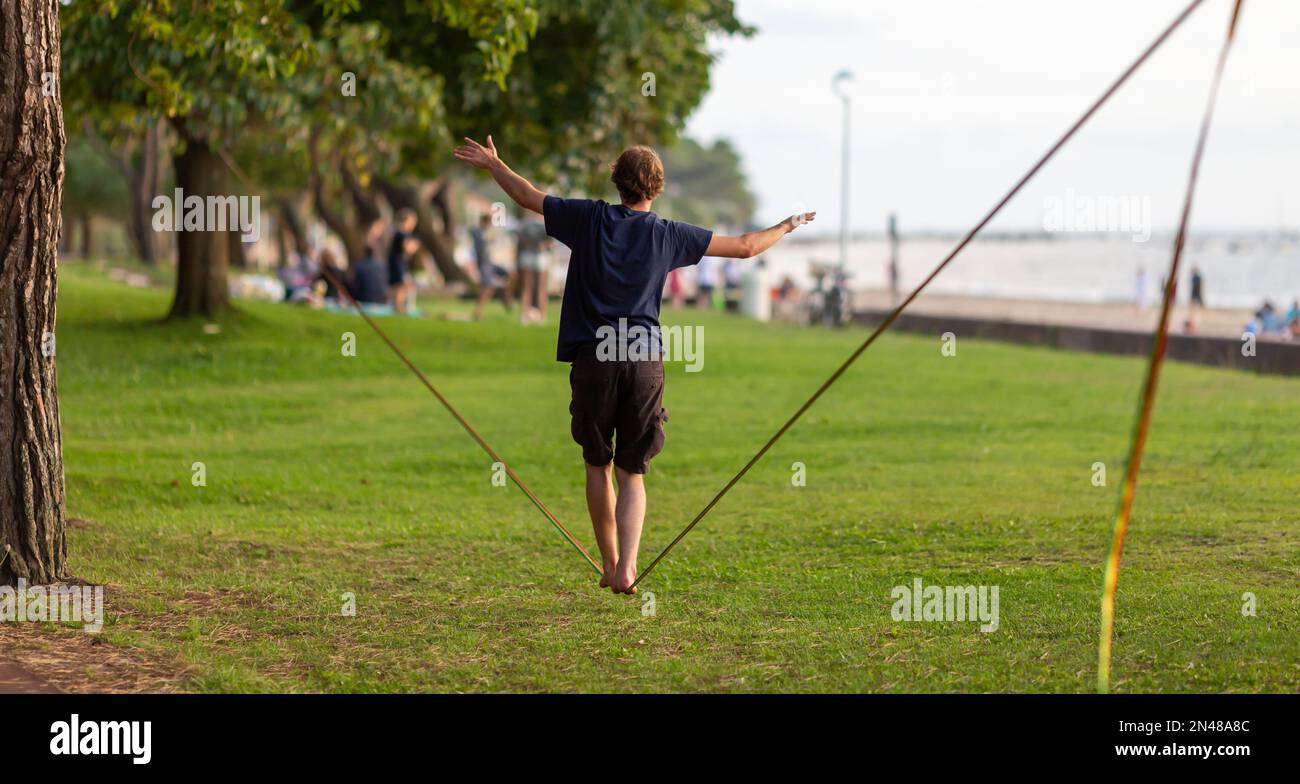 man walking on a slackline near the beach a sunny day Stock Photo - Alamy