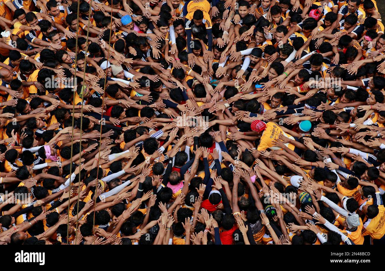 Indian youth make a human pyramid to reach and break the “Dahi Handi ...