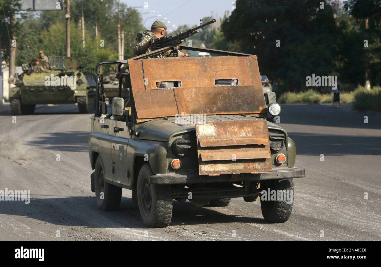 Pro-Russian rebels ride on an armored jeep in the town of Krasnodon ...