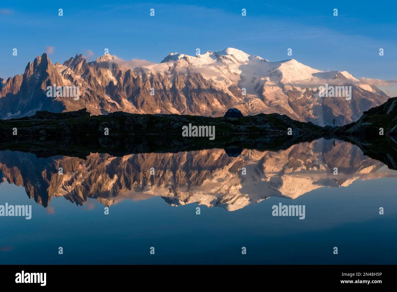 The peaks of the Mont Blanc massif, reflecting on the surface of Lacs des Chéserys at sunset ...