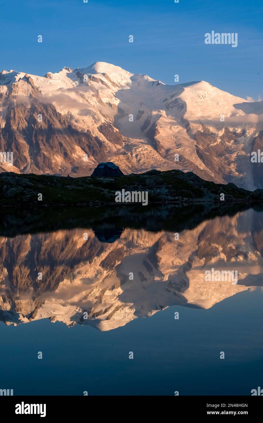 The peaks of the Mont Blanc massif, reflecting on the surface of Lacs des Chéserys at sunset ...
