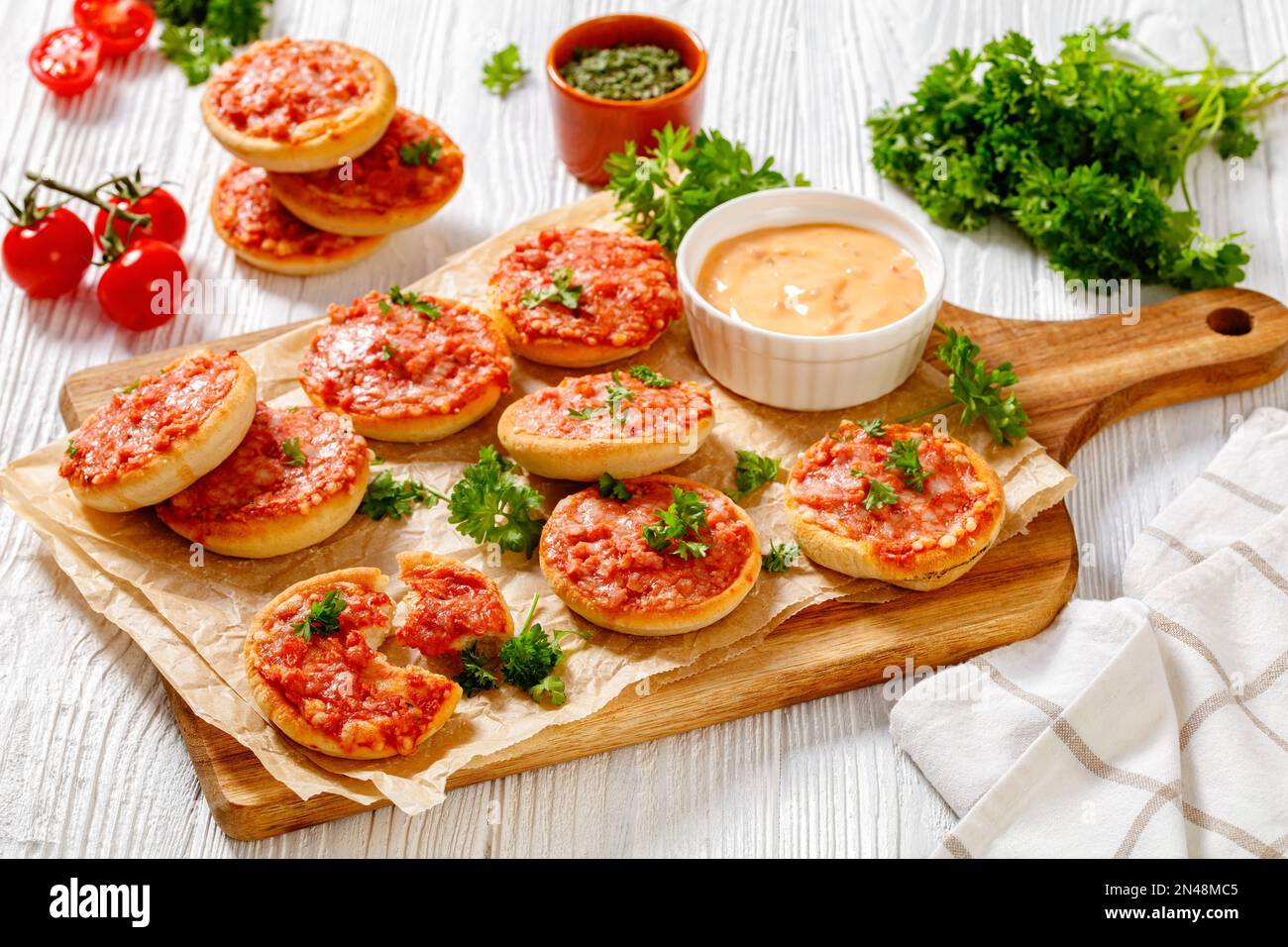 mini pizzas with ham and pecorino cheese on wooden cutting board with ...