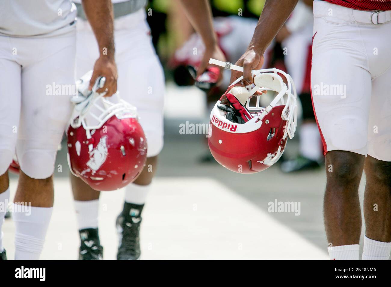 Two Arkansas defensive players walk onto the field holding their ...