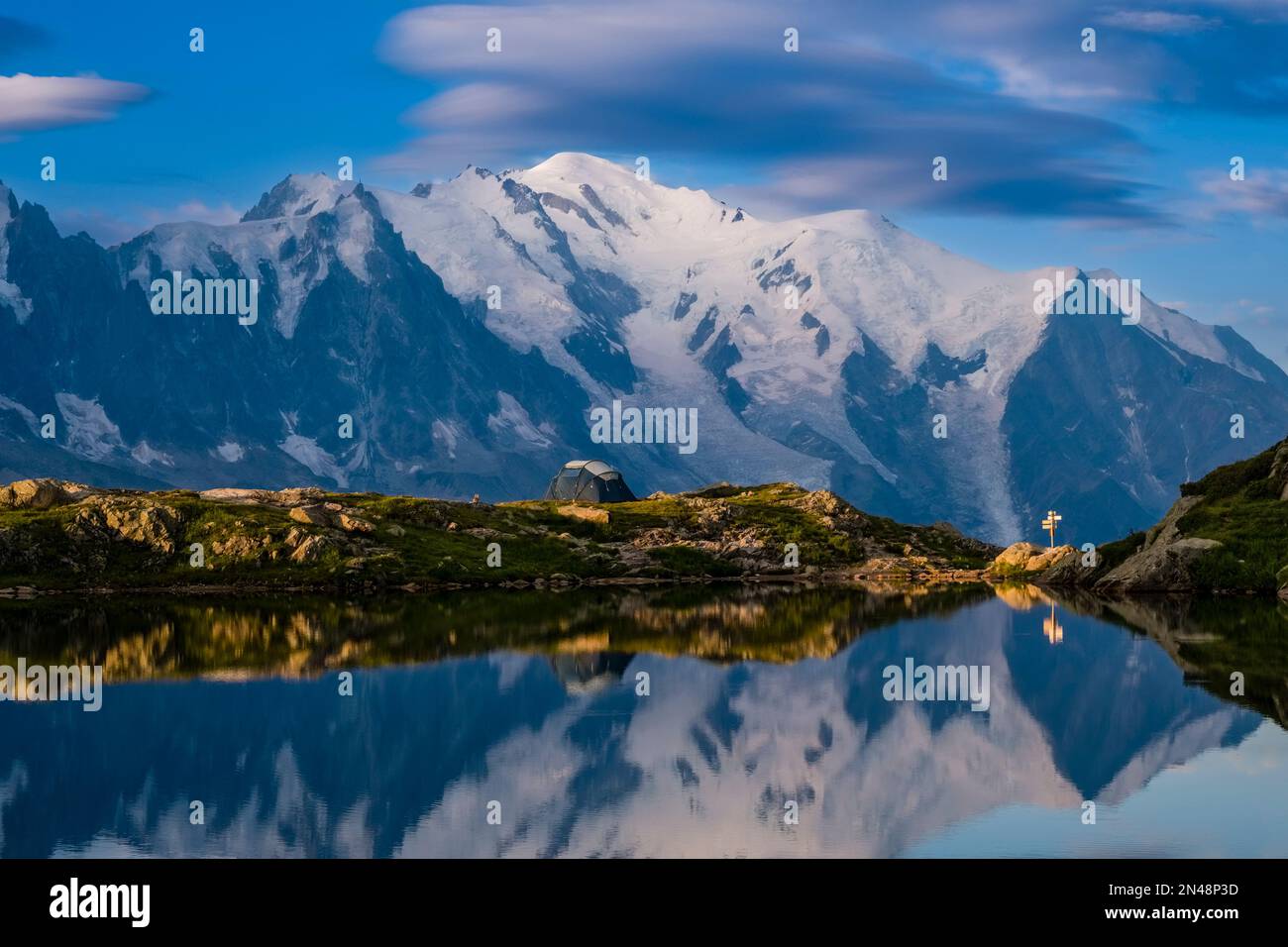 The peaks of the Mont Blanc massif and some clouds, reflecting on the surface of Lacs des ...