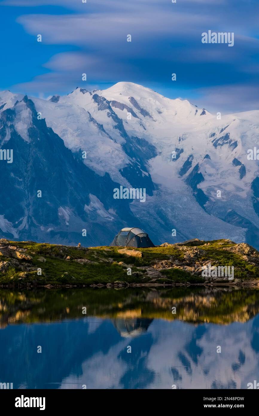 The peaks of the Mont Blanc massif and some clouds, reflecting on the surface of Lacs des ...