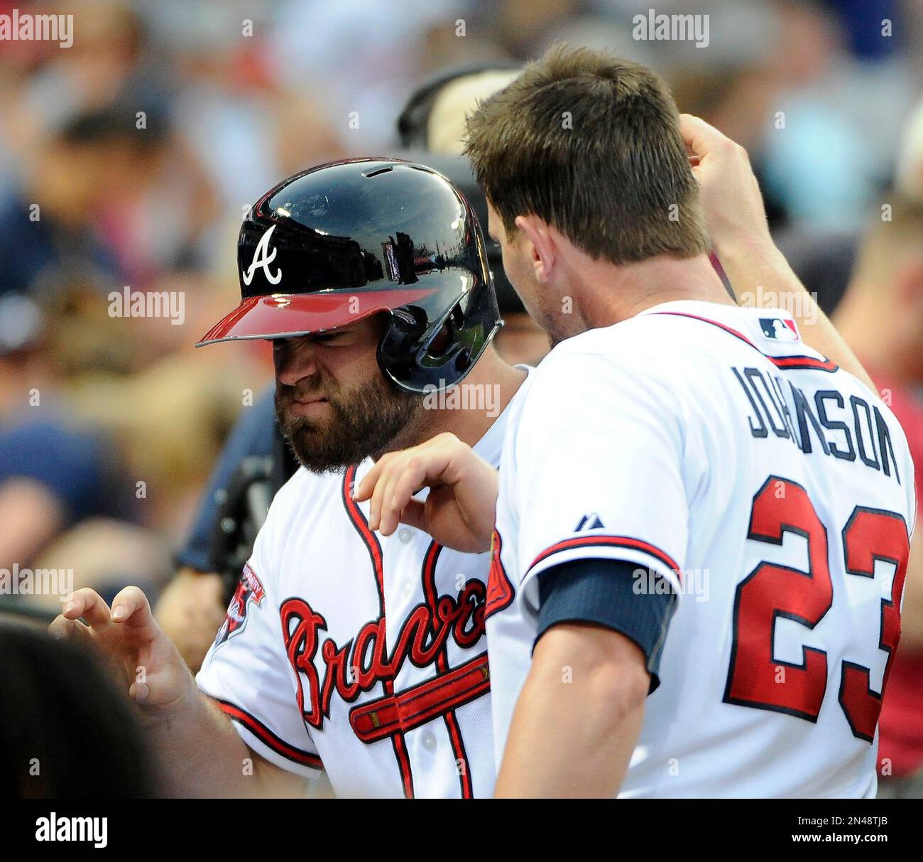Atlanta Braves' Evan Gattis, left, makes a face and pretends to claw at ...