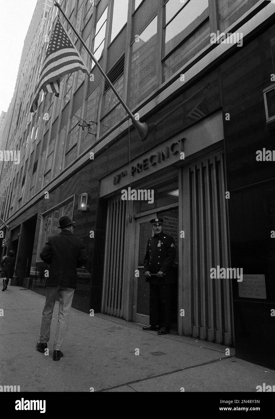 A police sergeant stands at the entrance to the 17th Precinct station ...