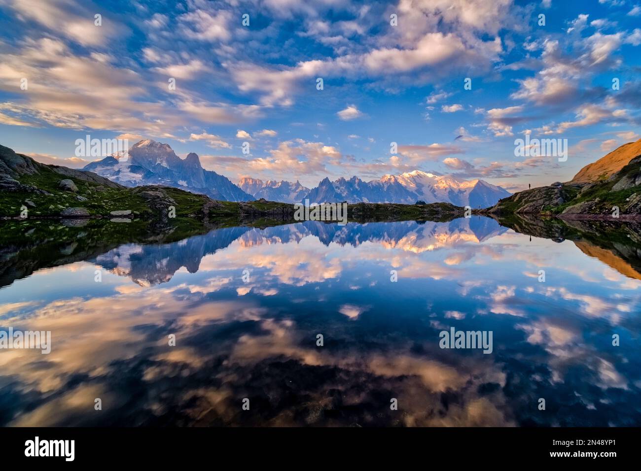 The peaks of the Mont Blanc massif and some clouds are reflecting in the Lacs des Chéserys at ...