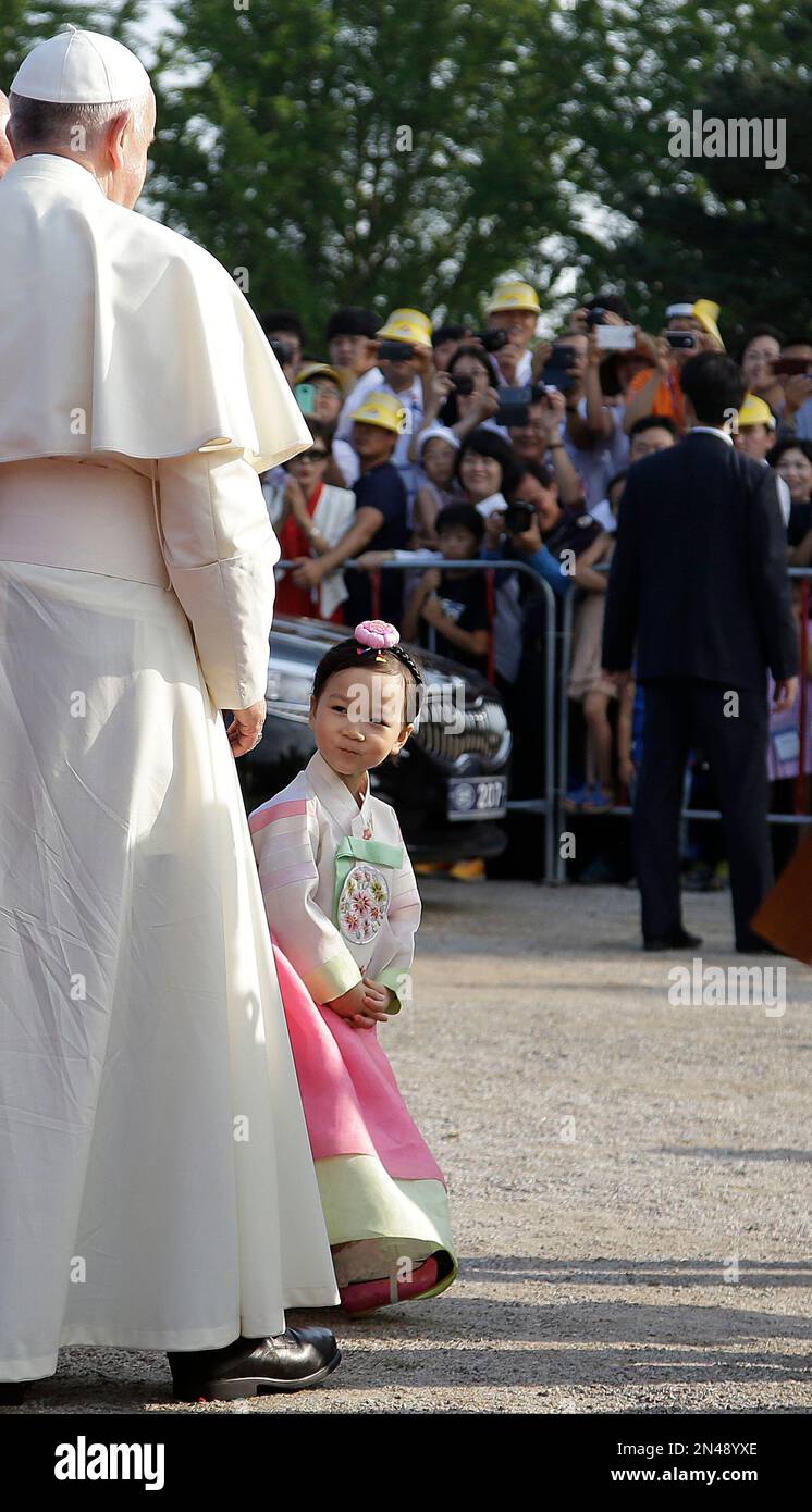 A child walks past Pope Francis after he prayed in front of the ...
