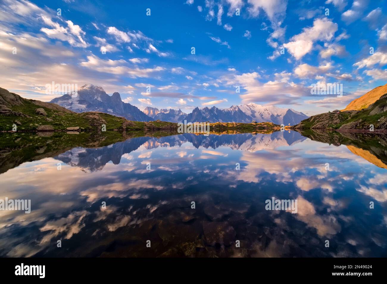 The peaks of the Mont Blanc massif and some clouds are reflecting in the Lacs des Chéserys at ...